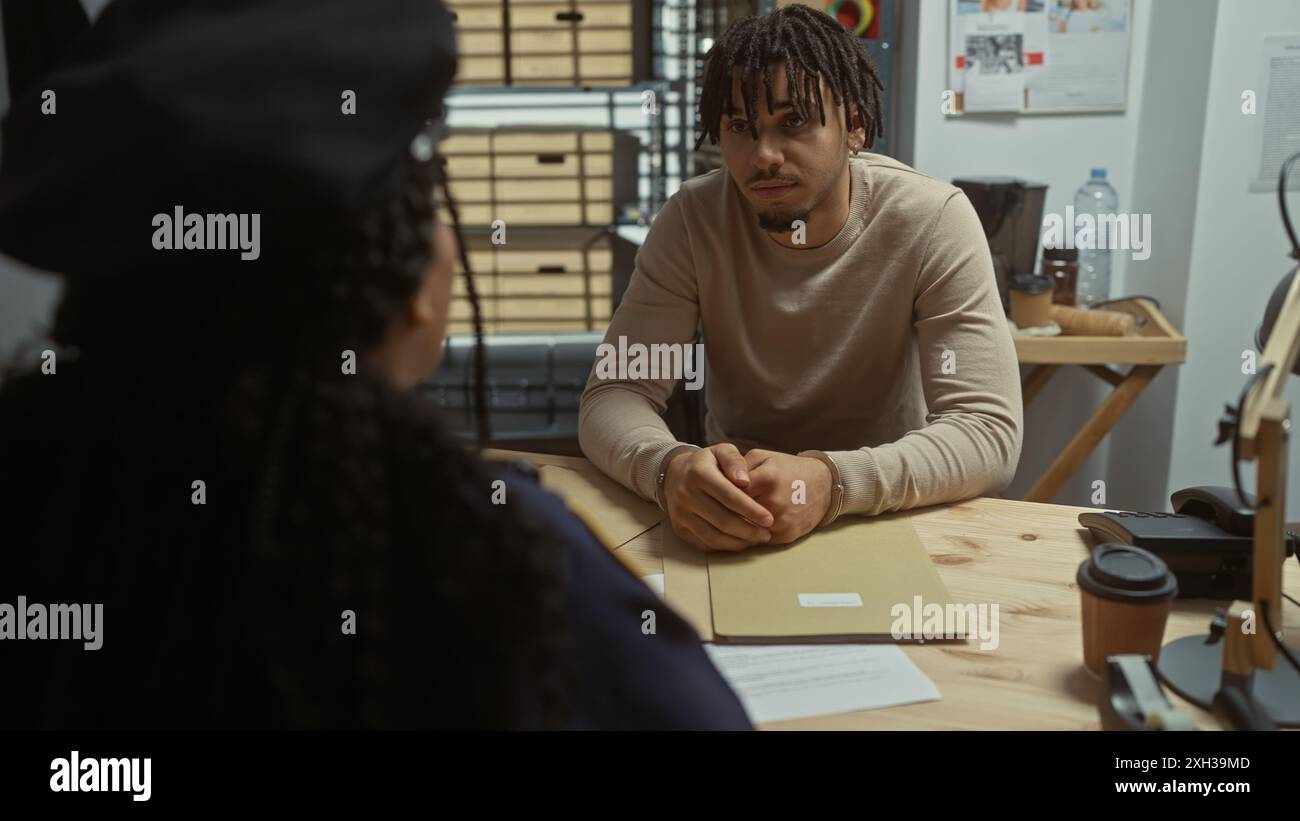A woman officer interviews a man in an interrogation room with ...