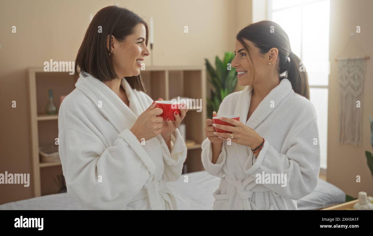 Two women in a spa wearing bathrobes, enjoying a relaxing moment with ...