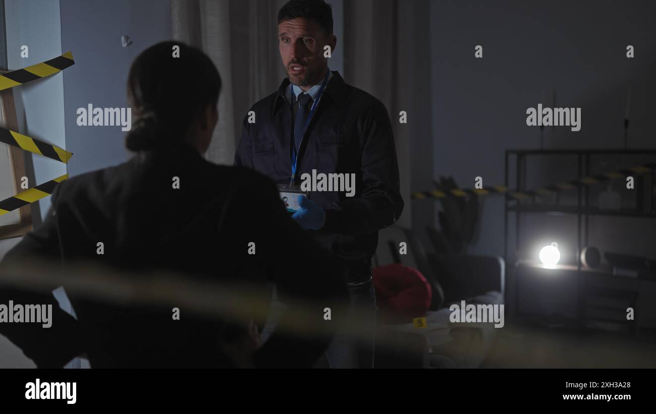 Investigators, a woman and a man, analyze clues at an indoor crime ...