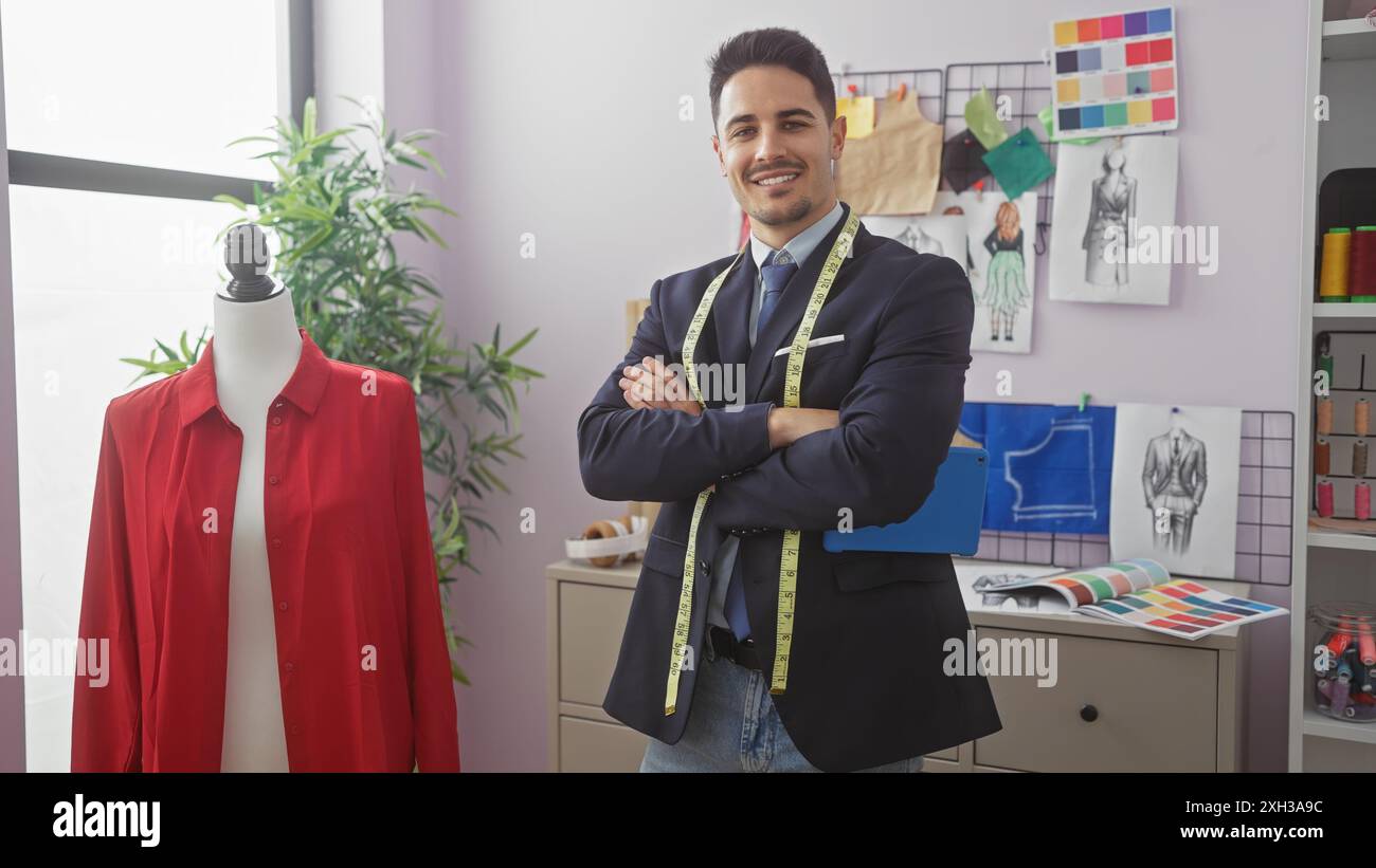 Handsome man with beard in tailor shop arms crossed, smiling in atelier ...