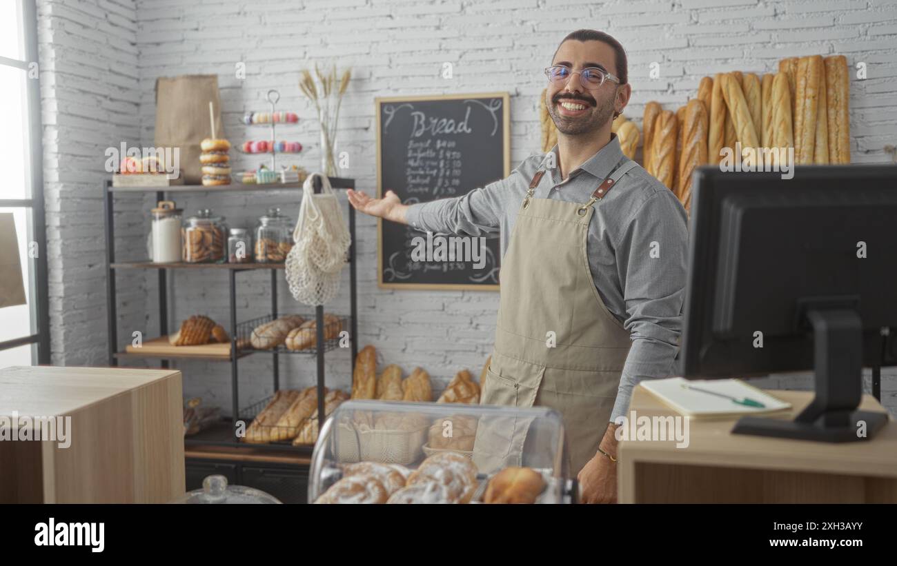 Young man with moustache in bakery, showcasing bread and smiling near ...