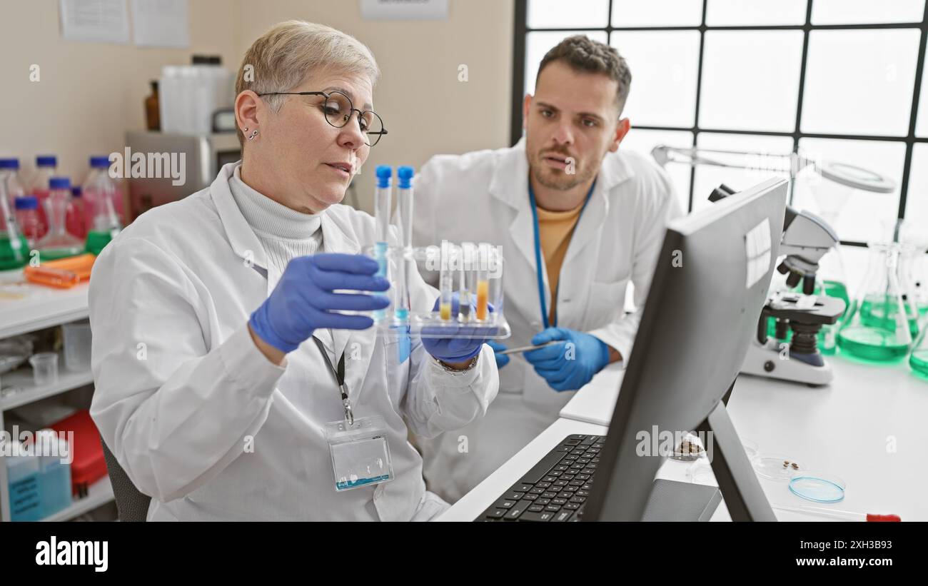Man and woman scientists in lab conducting research with test tubes and ...