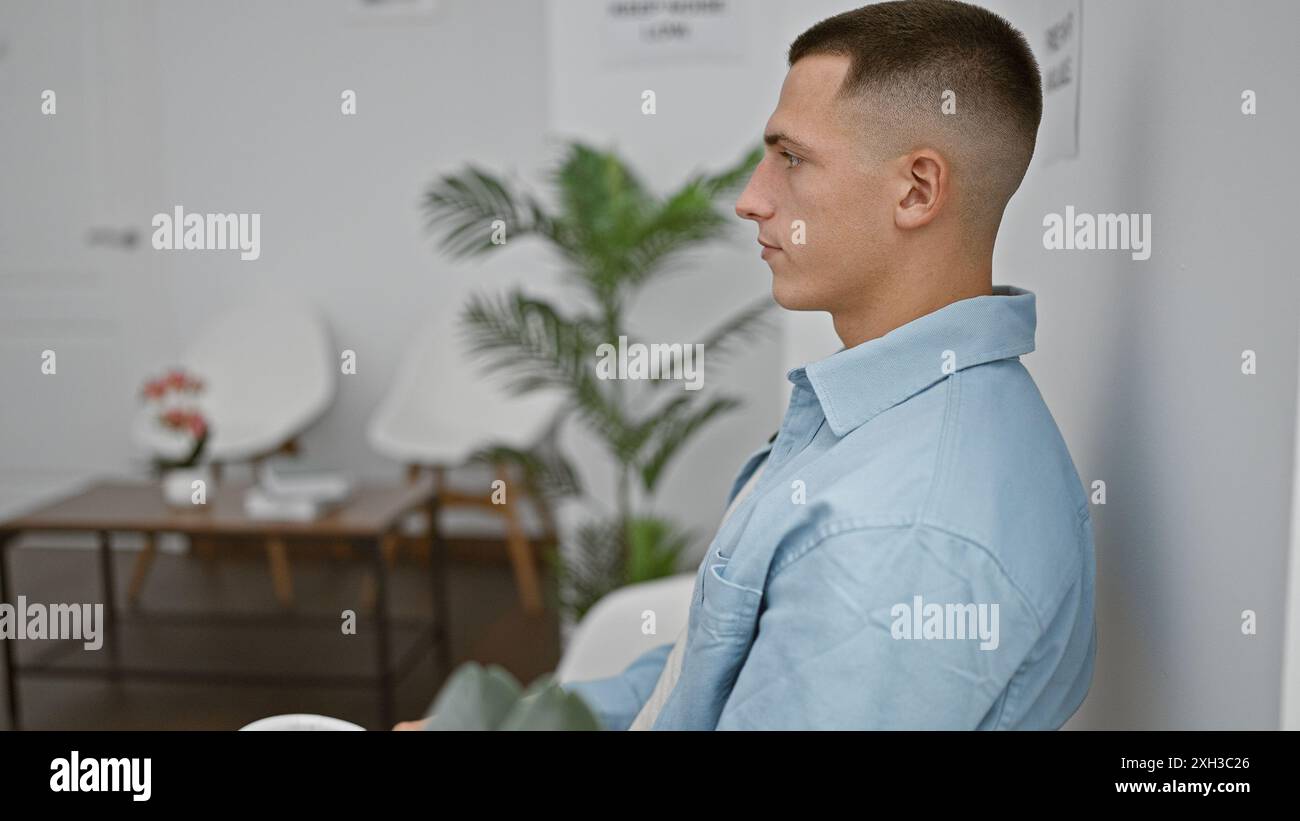 Side profile of a young hispanic man sitting thoughtfully in a modern ...