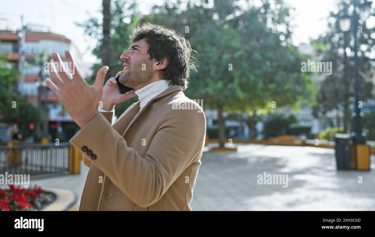 A young hispanic man gestures animatedly while talking on the phone in ...
