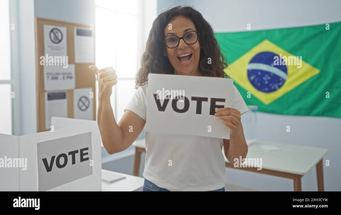 Hispanic woman making a thumbs-up gesture while holding a vote sign in ...