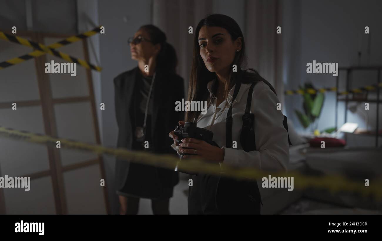 Two women investigators with badges and camera inspect a dimly lit ...