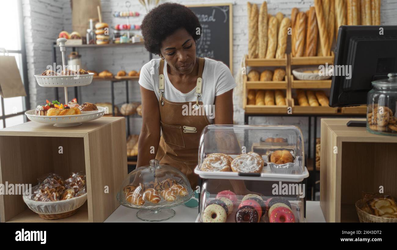 African american woman with curly hair in a bakery shop surrounded by ...