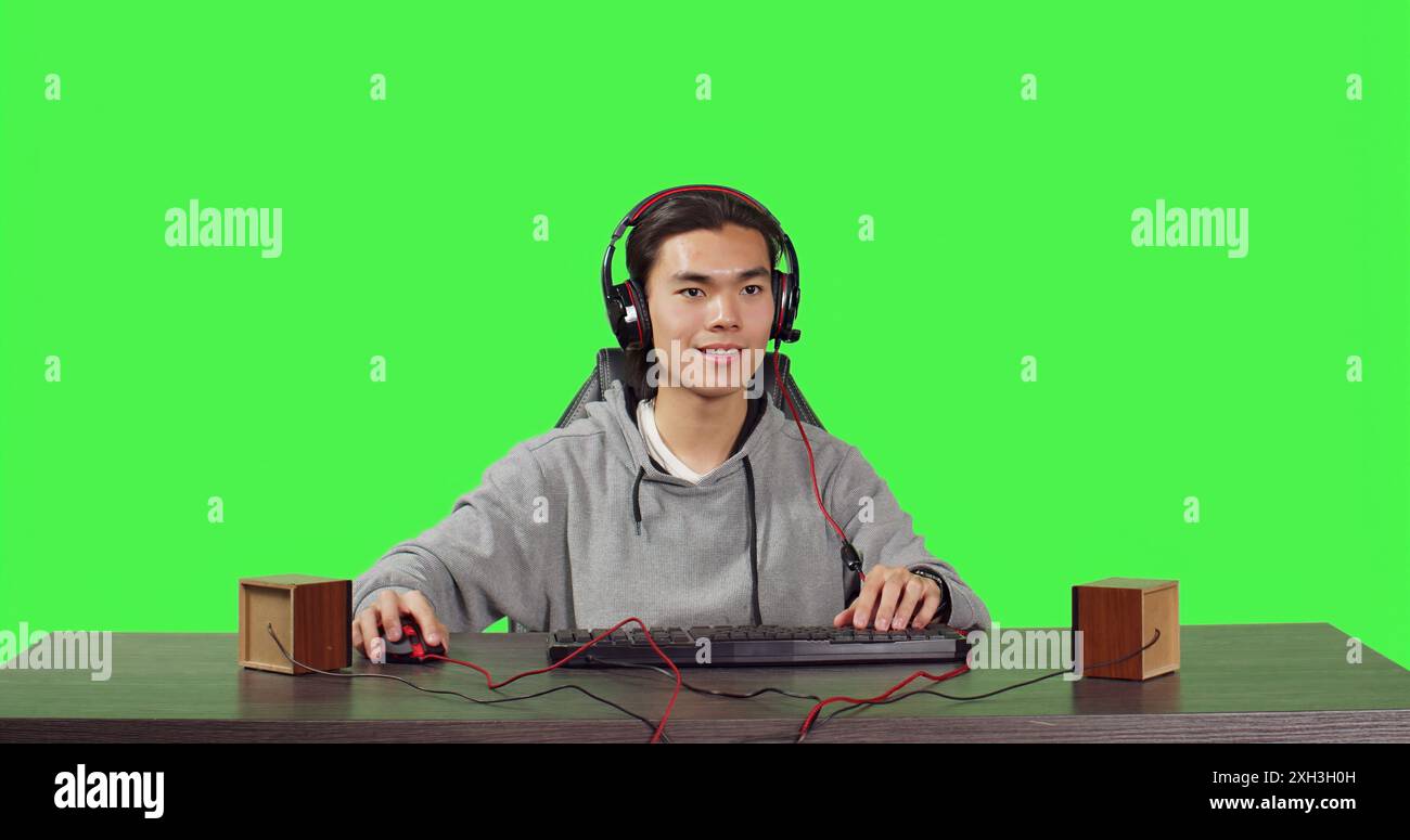 POV of asian guy playing at pc desktop, sitting against full body ...