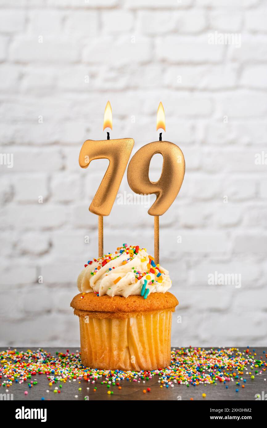 Golden birthday candle number 79 with cupcake - White block wall ...