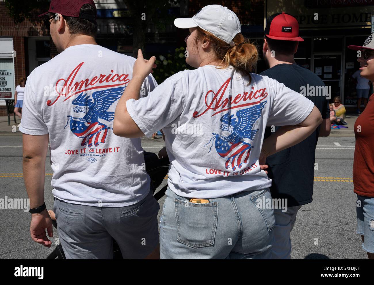 A couple wearing matching "America Love It or Leave It" T-shirts watch ...