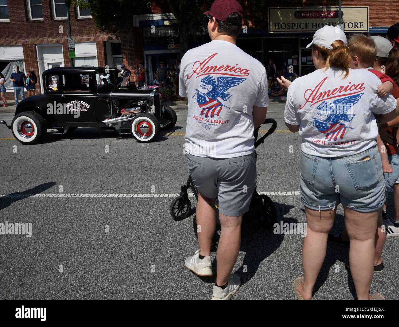 A couple wearing matching "America Love It or Leave It" T-shirts watch ...