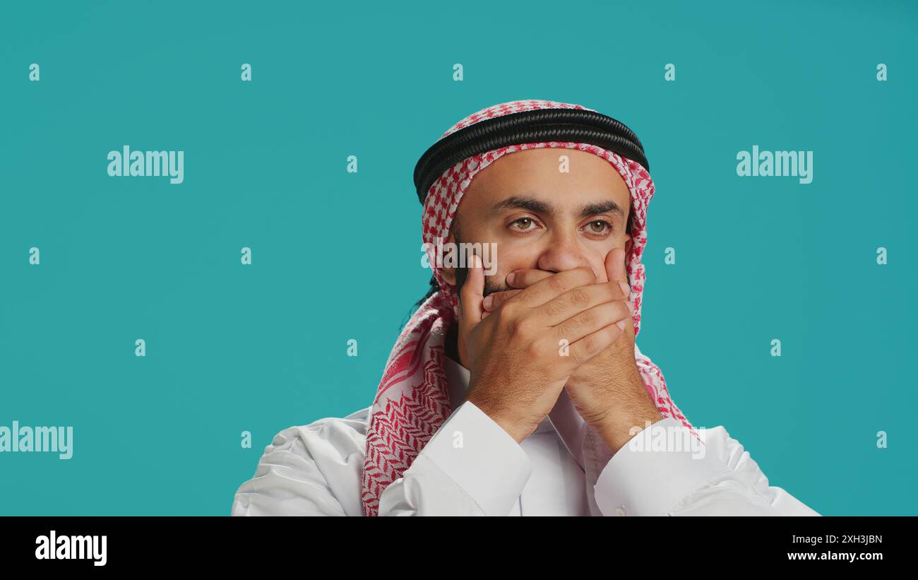 Muslim guy covers eyes, ears and mouth on camera, showing three wise ...