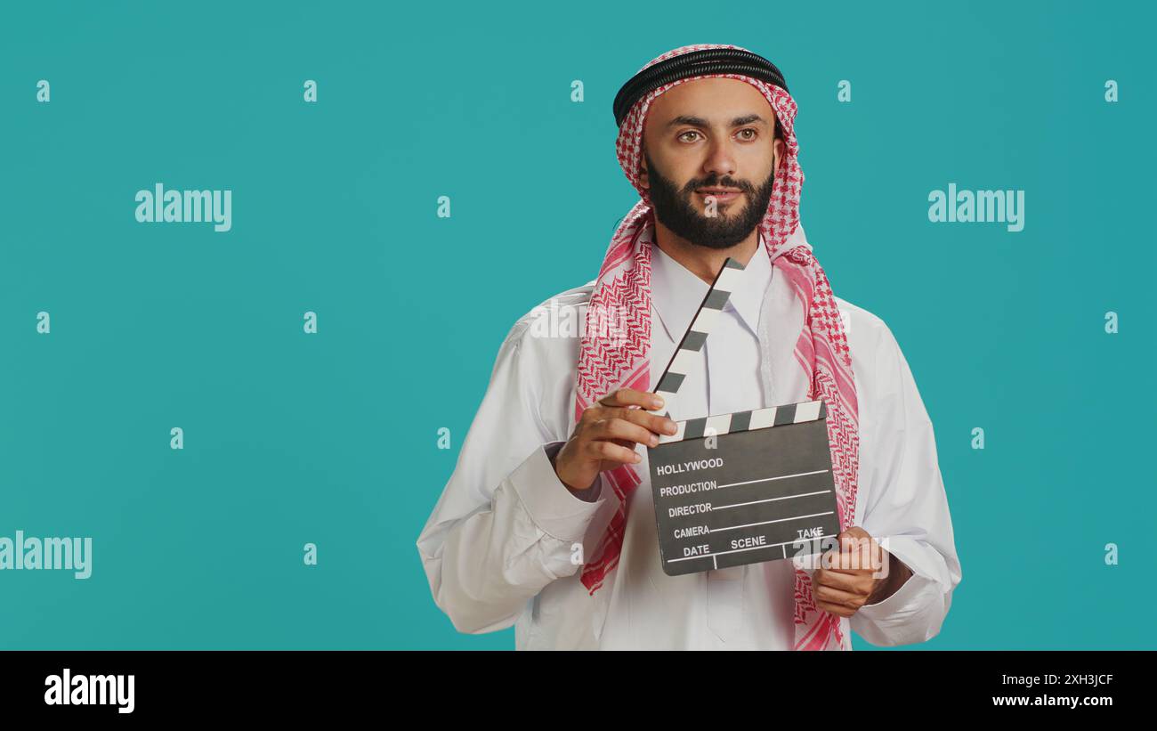 Middle eastern man holds clapperboard used for action takes on movie ...