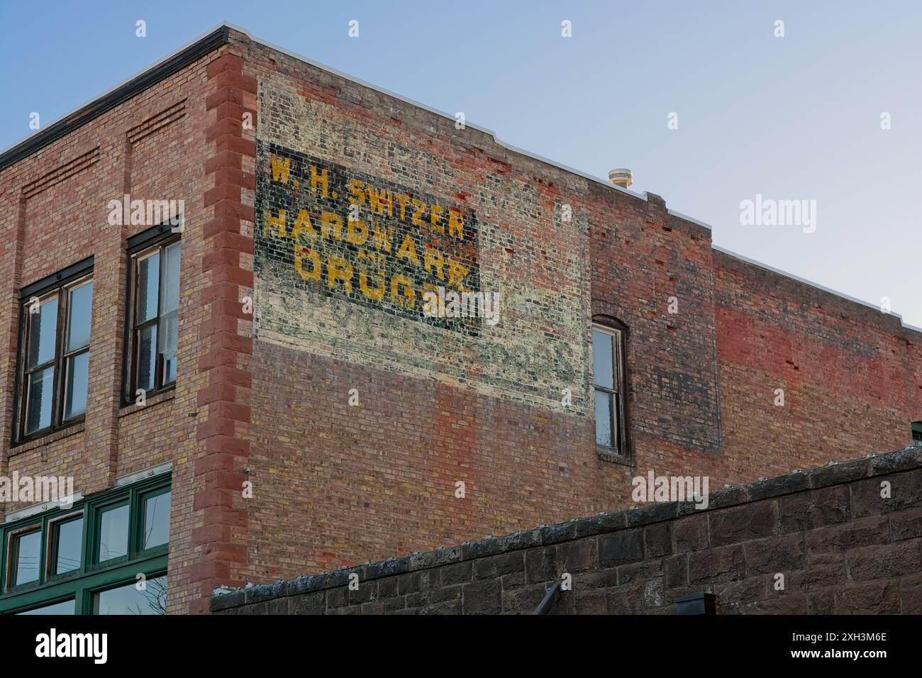 Layered faded ghost signs on old brick building Stock Photo - Alamy