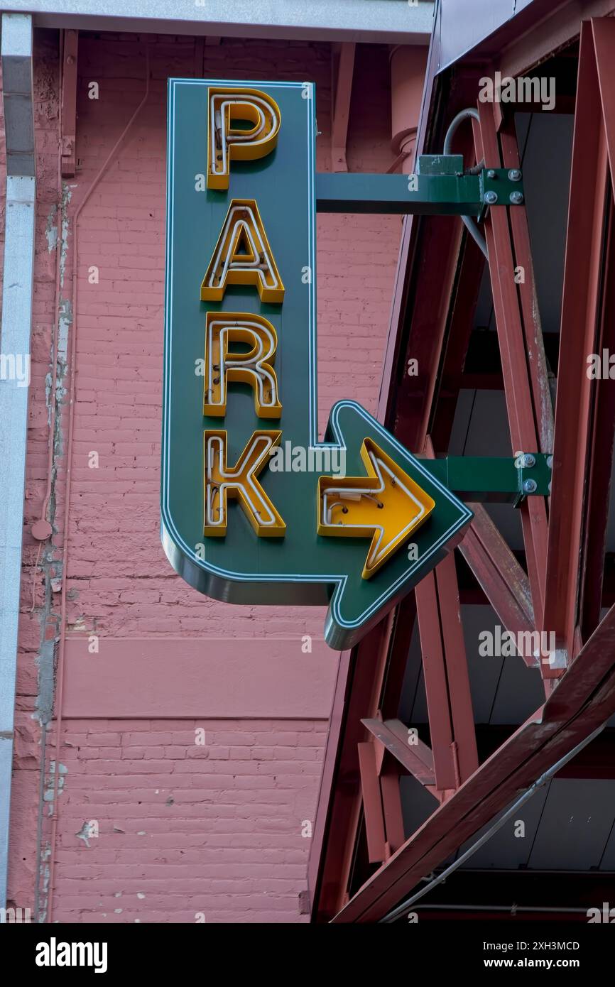 Stylized parking garage neon entrance sign hung from steel roof truss ...