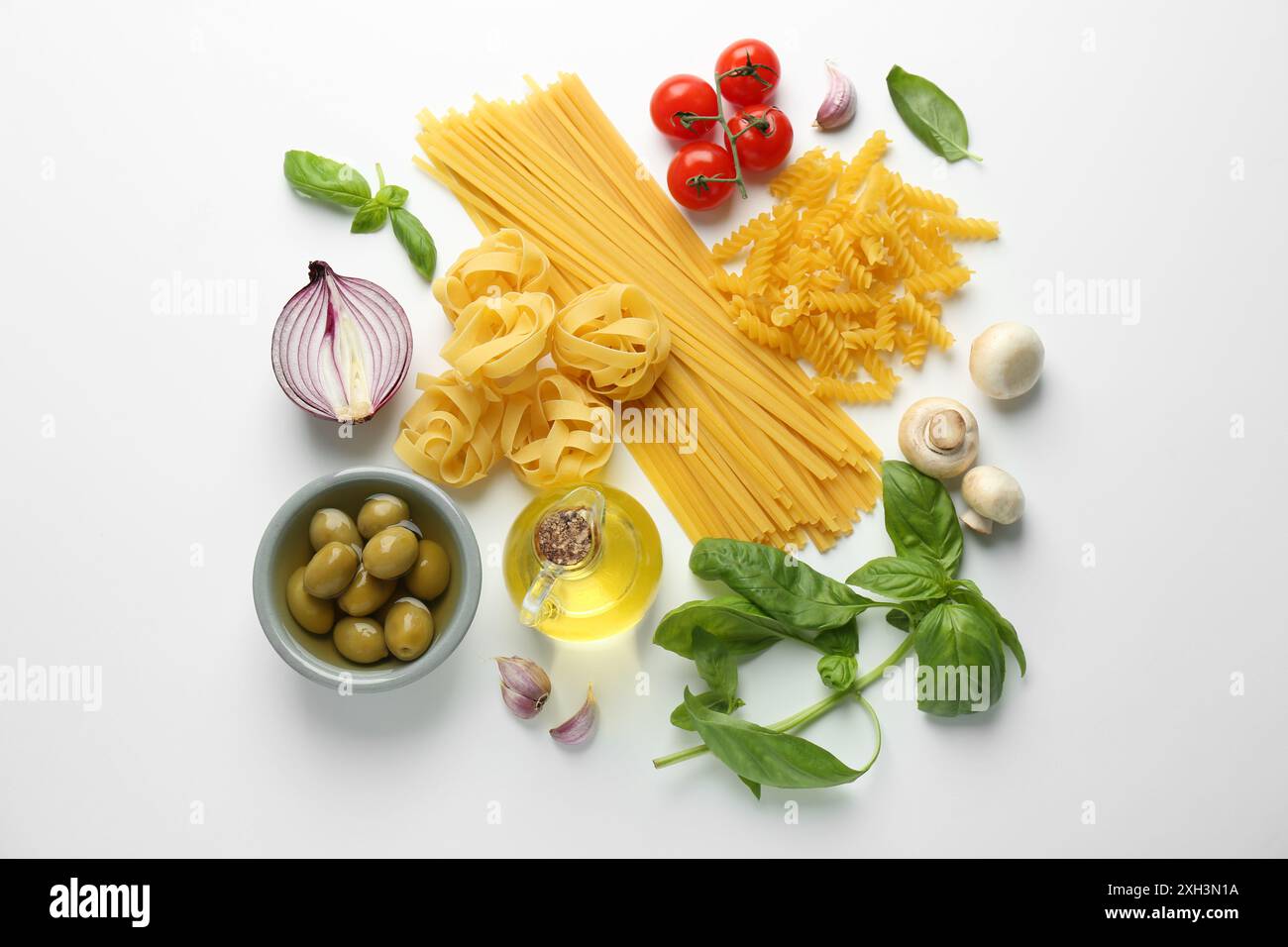 Different types of pasta, spices and products on white background, top ...