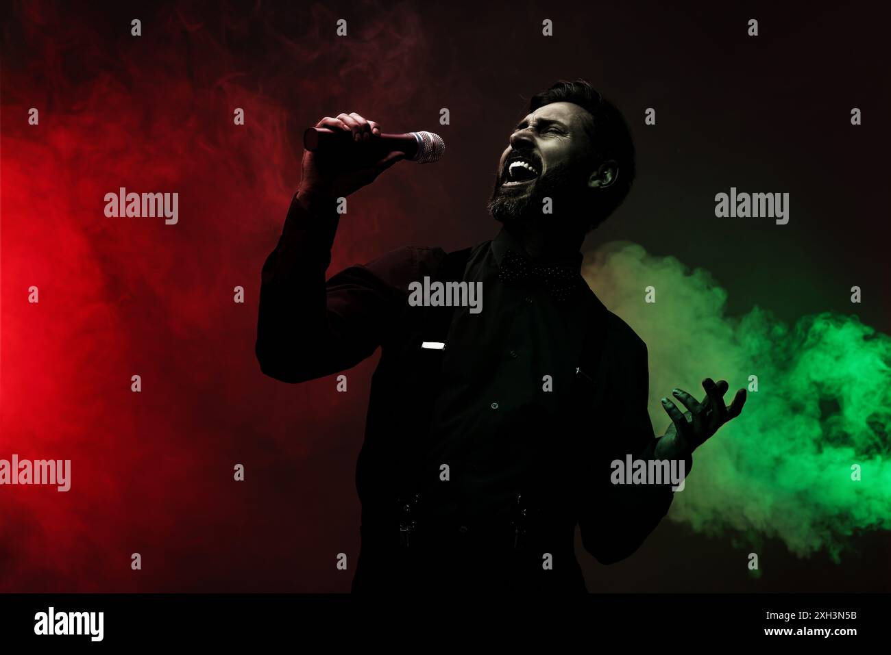 Singer with microphone in neon lights on stage Stock Photo - Alamy