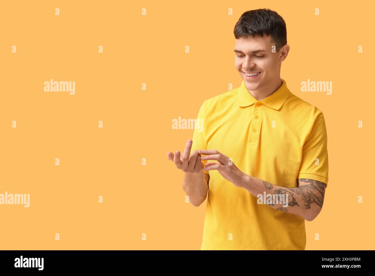 Young deaf mute man using sign language on yellow background Stock Photo - Alamy