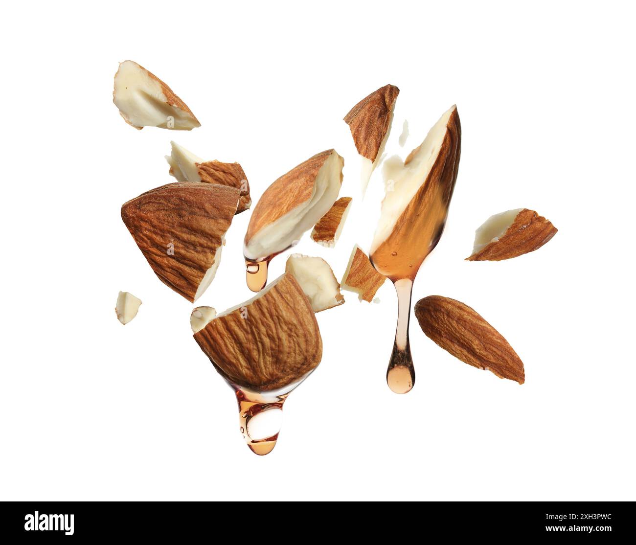 Oil dripping from crushed almonds on white background Stock Photo - Alamy
