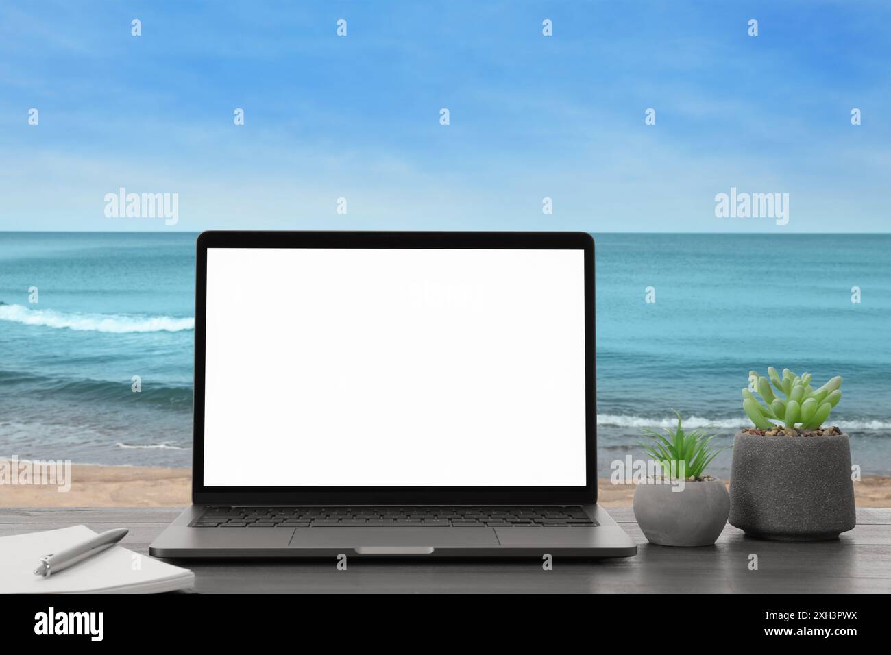 Workplace at beach, distant office. Table with laptop on sandy seashore ...