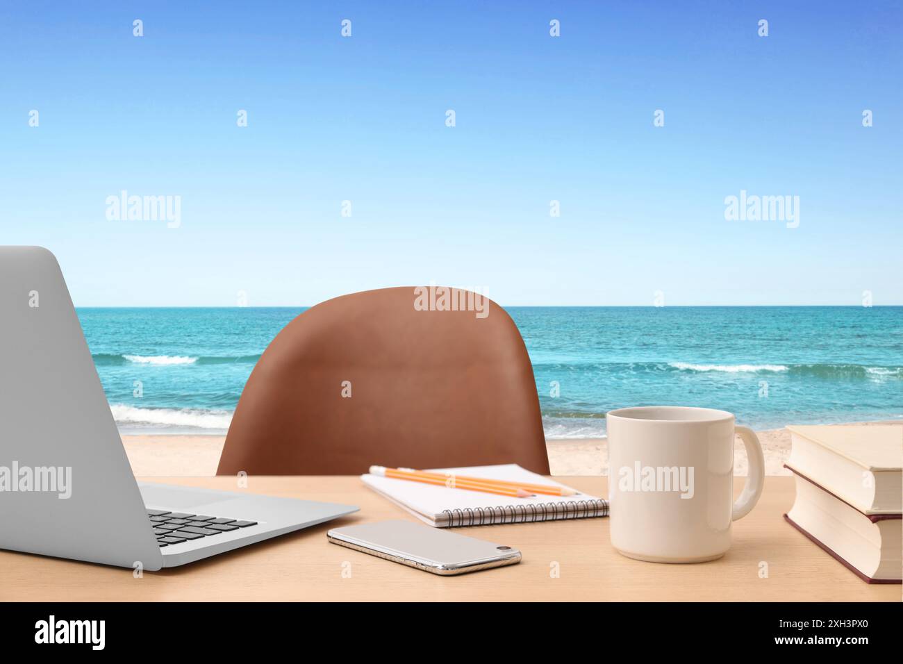 Workplace at beach, distant office. Table with laptop and chair on ...