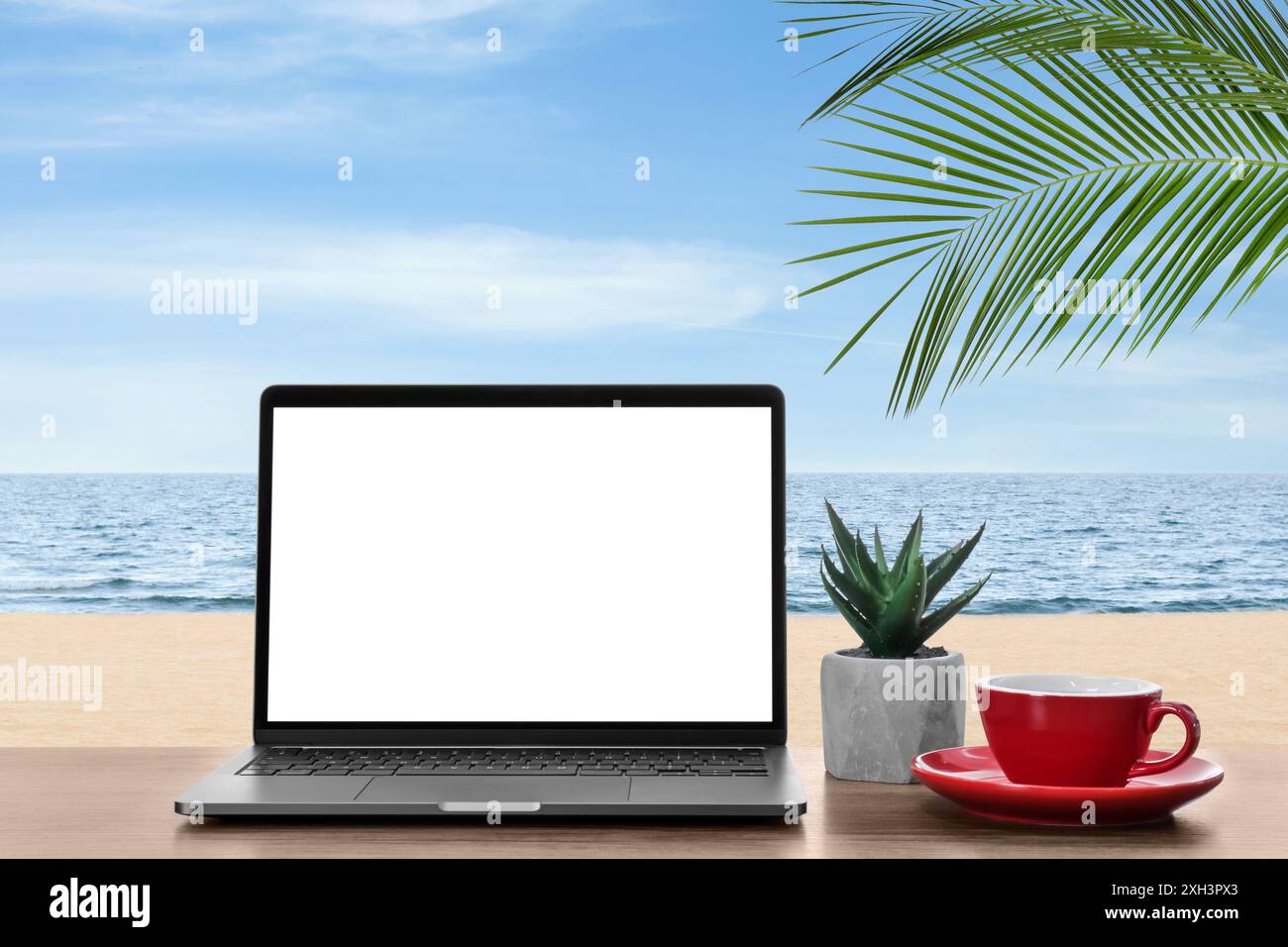 Workplace at beach, distant office. Table with laptop on sandy seashore ...