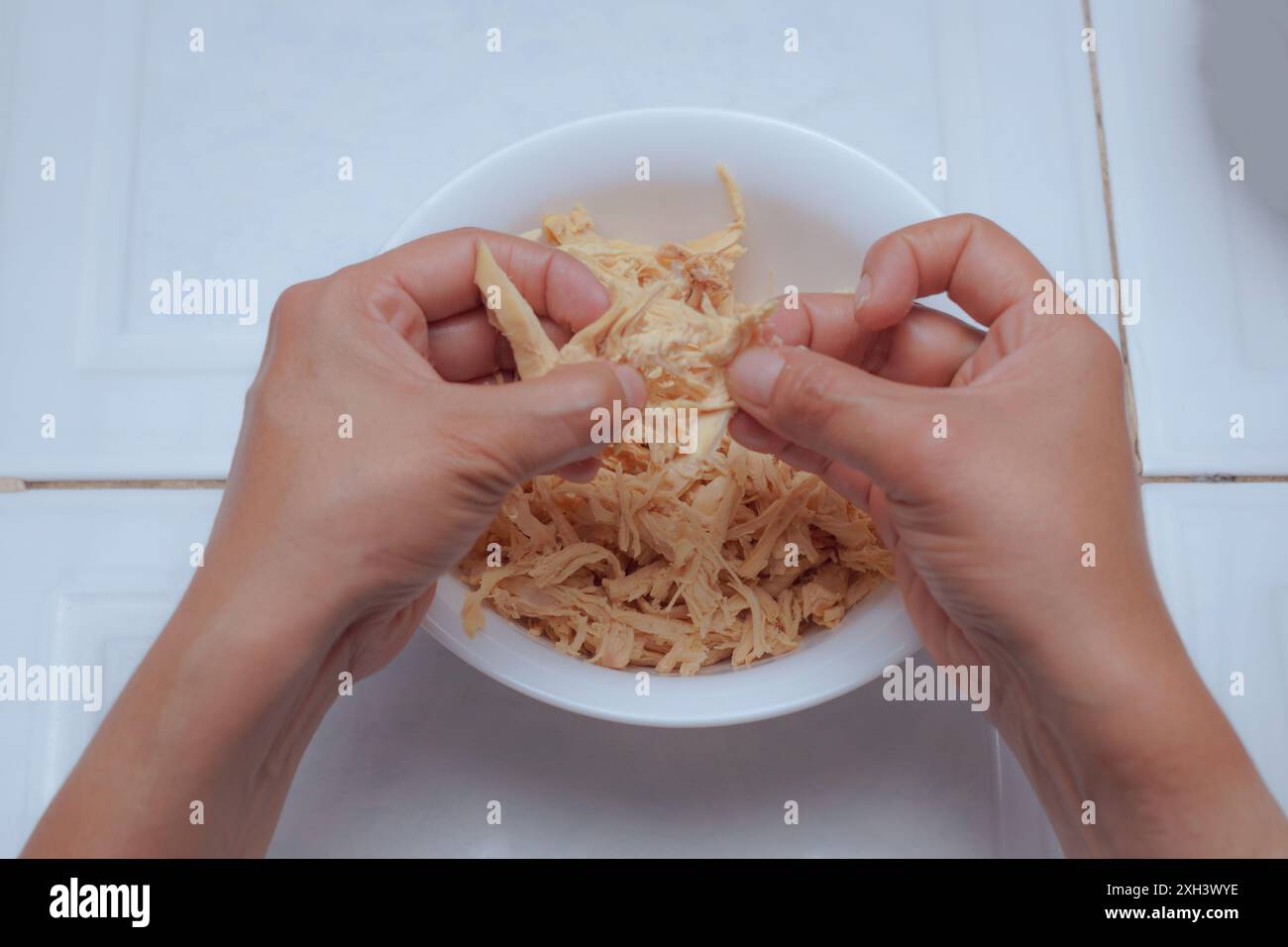 Chef's hands preparing boiled chicken, shredding chicken, cooking on ...