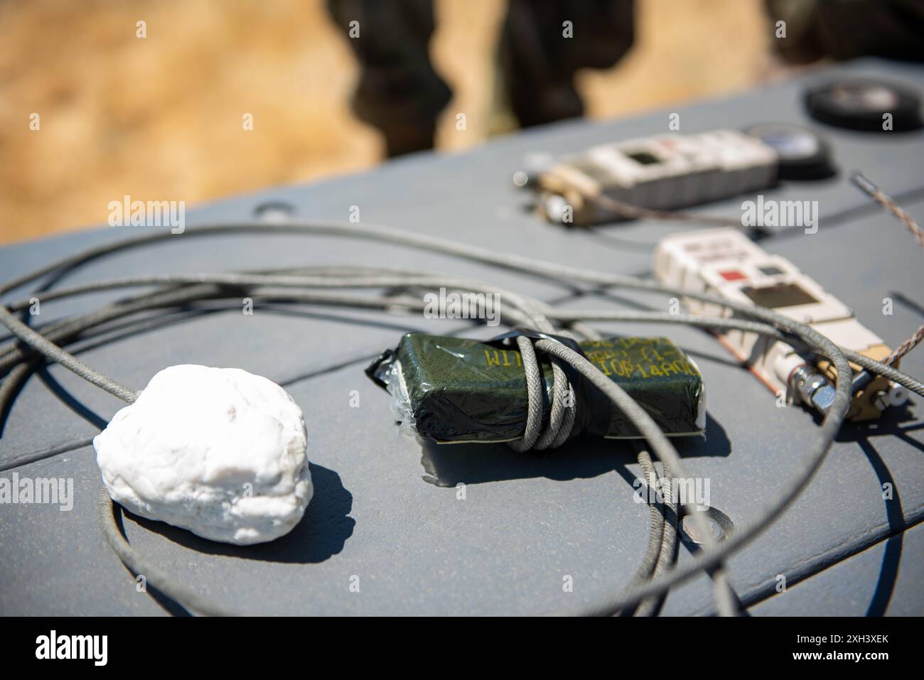 C-4 explosive, detonating cord and firing devices rest on a table ...