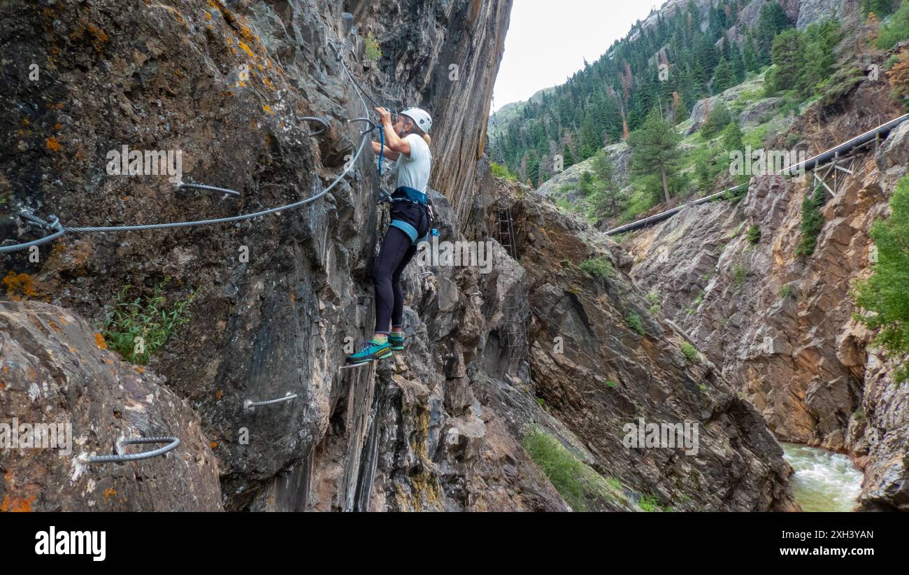 A single woman climbing a via ferrata in Ouray, Colorado Stock Photo ...