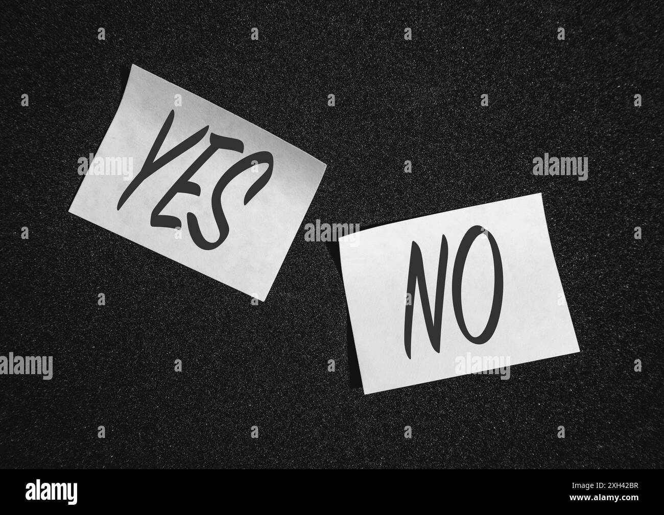 Two sticky notes on a black background with yes and no Stock Photo - Alamy