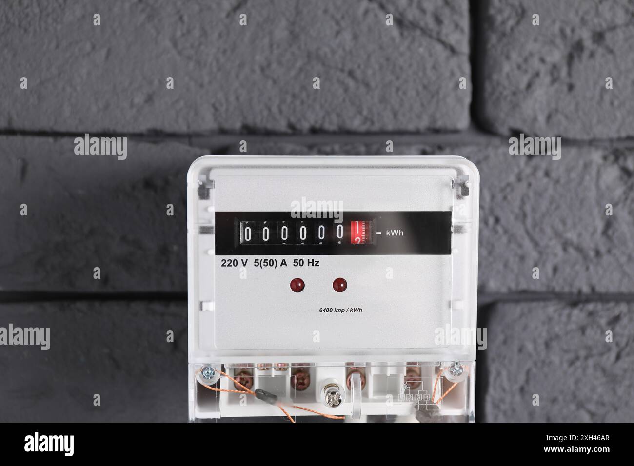 Electric meter on grey brick wall. Energy measuring device Stock Photo ...