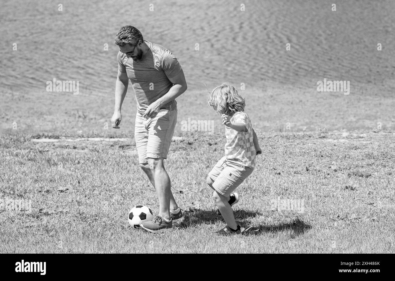 Father and son enjoy a friendly game of football. happy childhood of ...