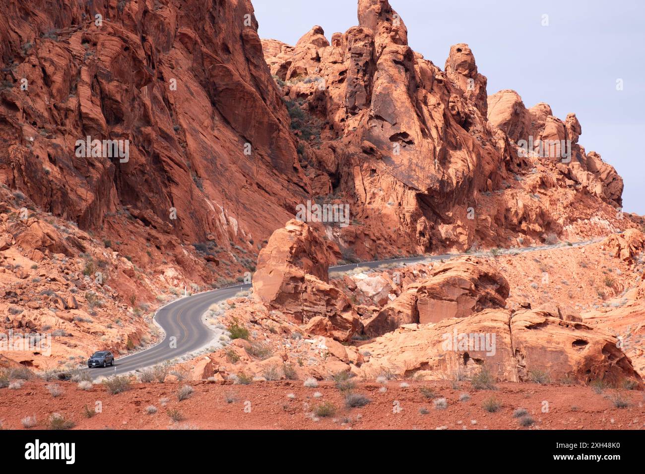 Car traversing a pass among vibrant desert red rocks of Valley of Fire ...