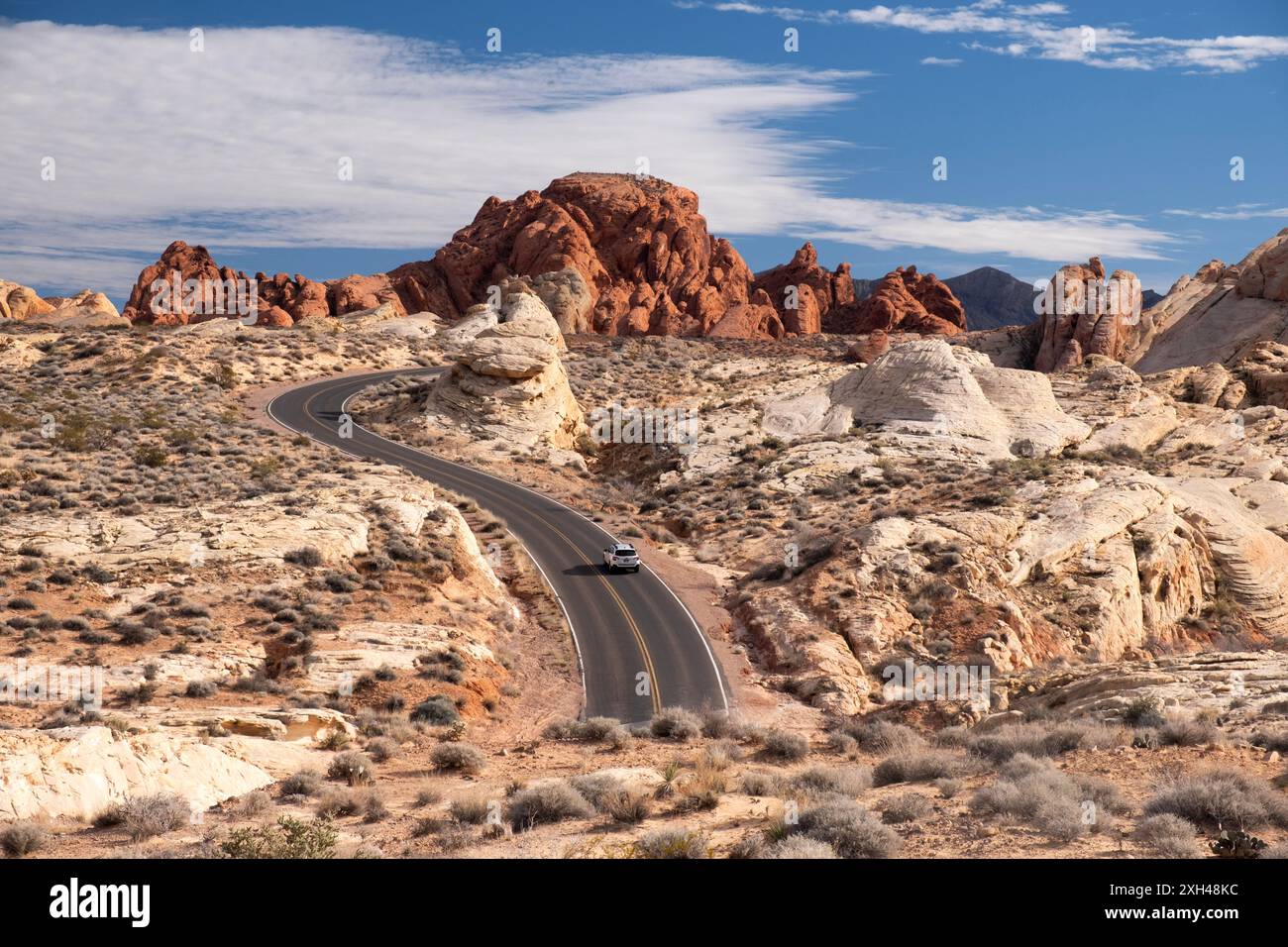 Single car driving down a curving desert highway in Valley of Fire ...