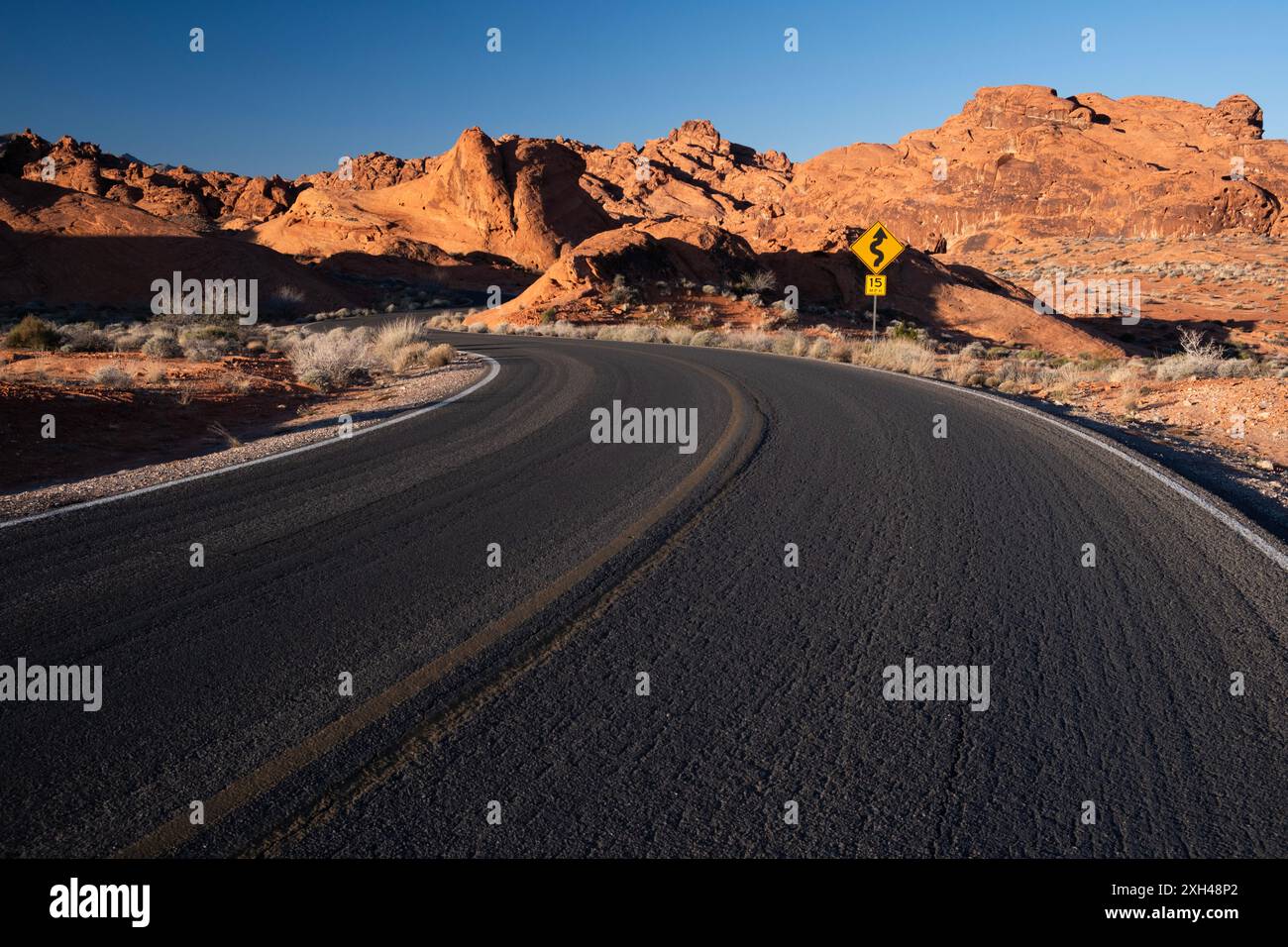 Curving asphalt highway through the desert among the rock formations at ...