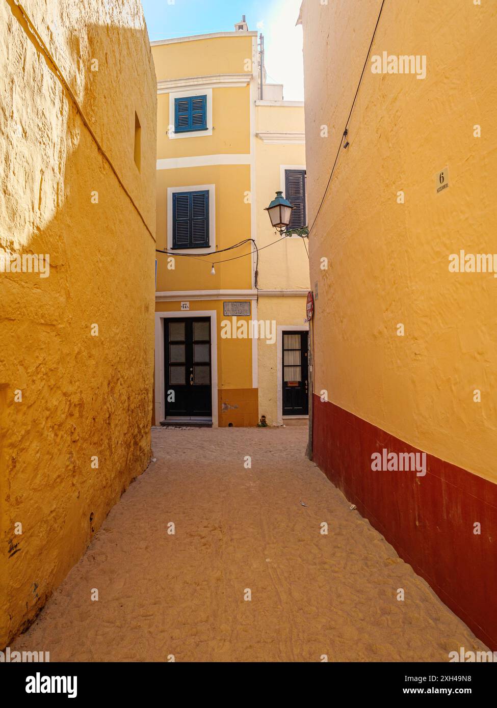 Narrow sandy street between yellow buildings in Spain Stock Photo - Alamy
