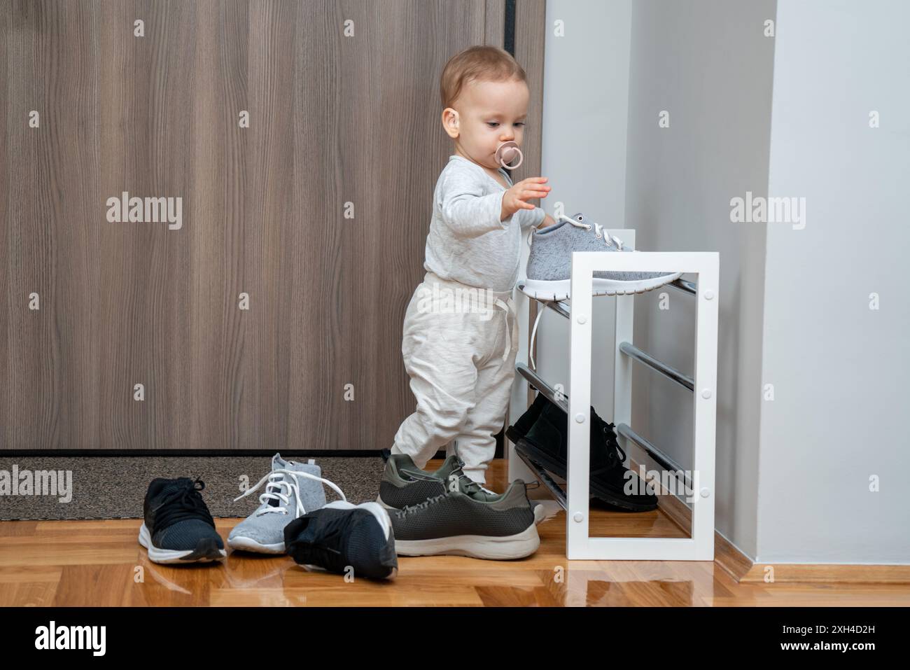 A child throws adults' shoes from a stand at the entrance. Pranks and ...