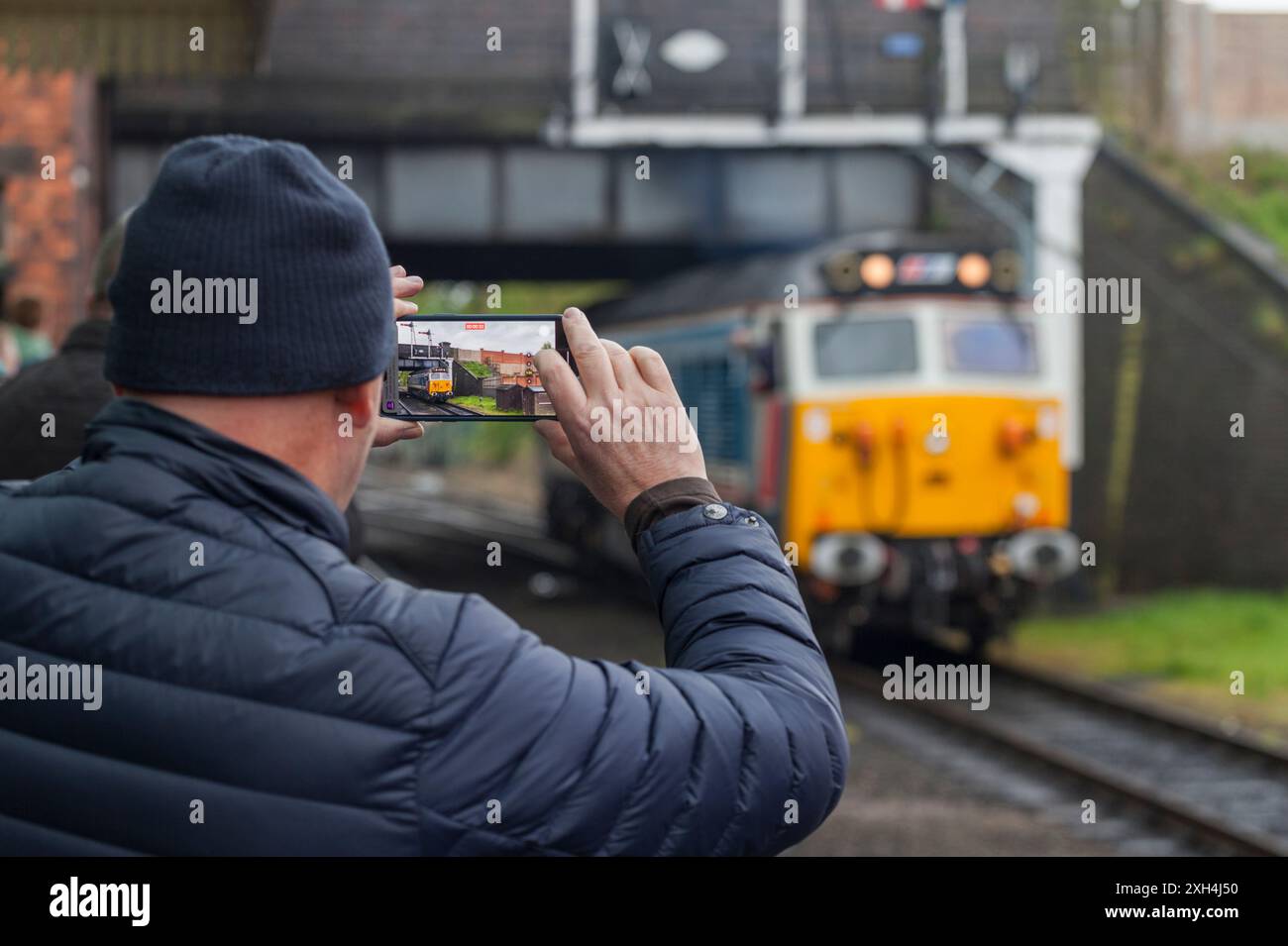 Rail enthusiast taking a mobile phone picture of preserved class 50 ...