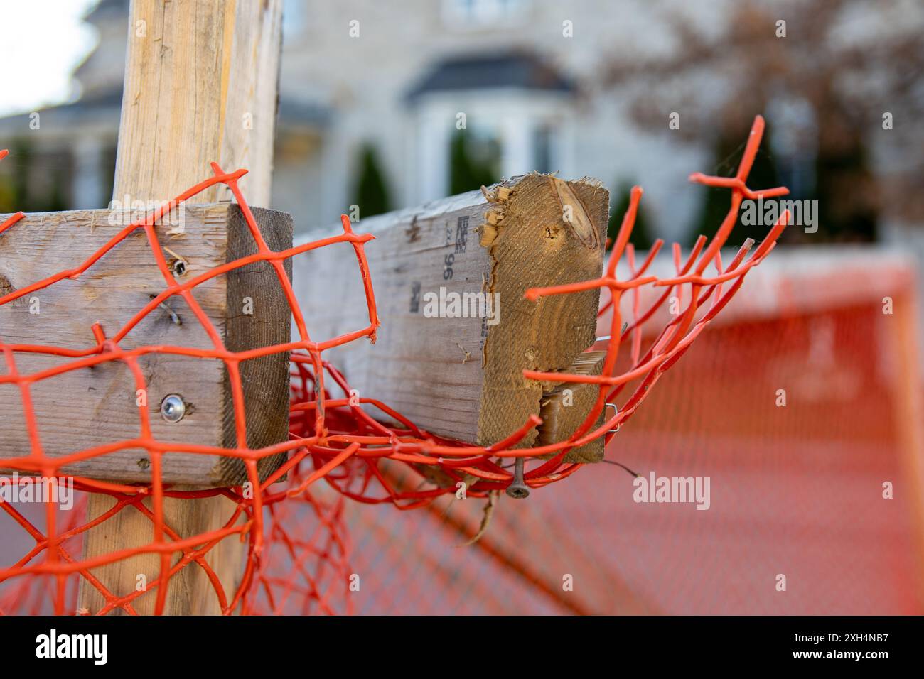 Orange safety fence - wrapped around wooden post - blurred residential ...