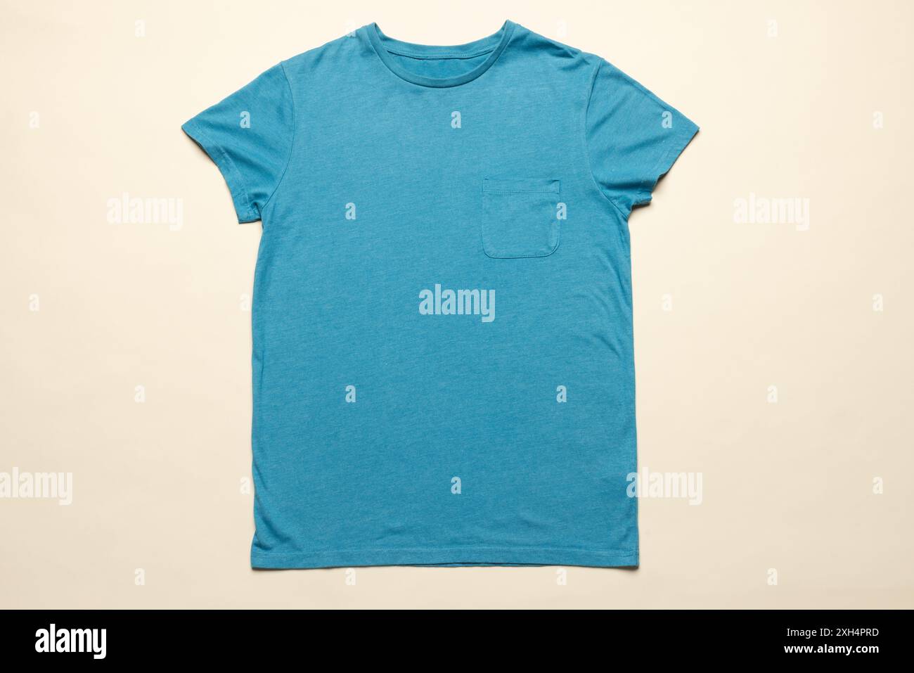 A plain blue t-shirt is laid out flat against a neutral background ...