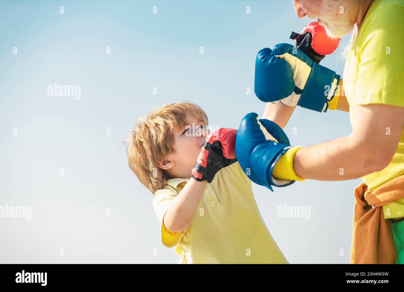 Funny bearded man - grandfather with child boy standing in boxing pose ...