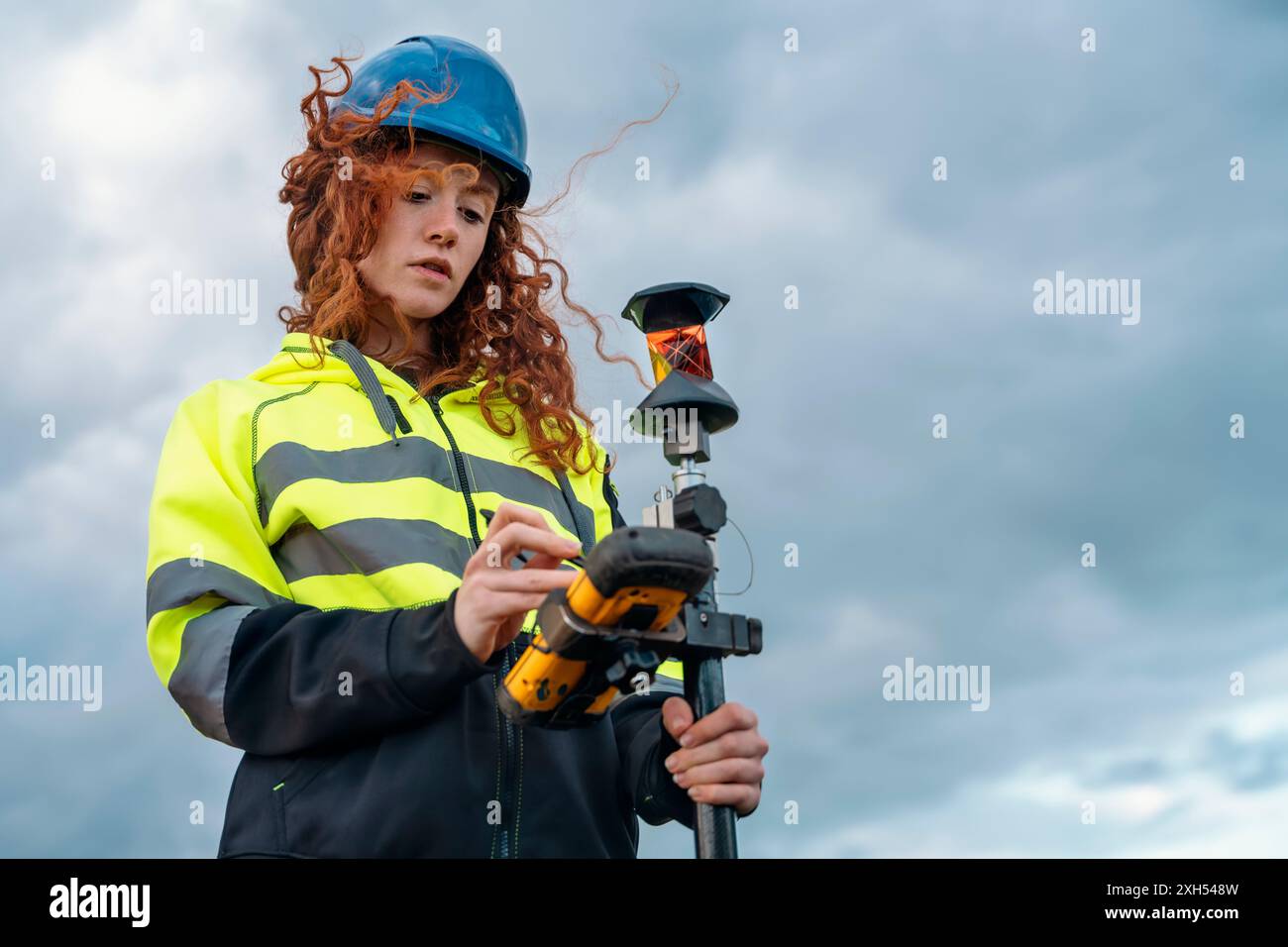 Female site engineer surveyor working with theodolite total station EDM ...