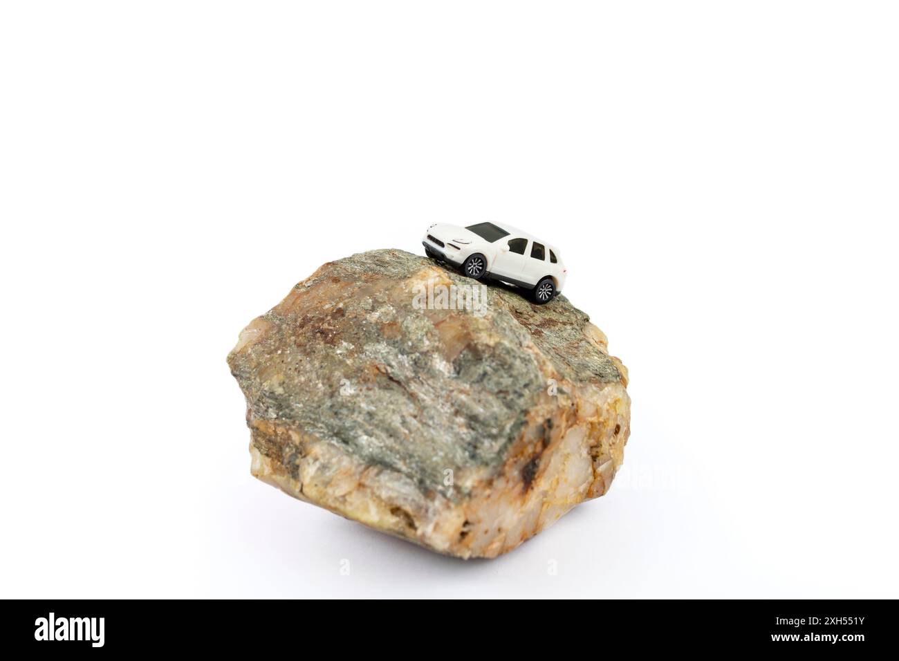Small generic suv model car climbing a rock in balance isolated on ...