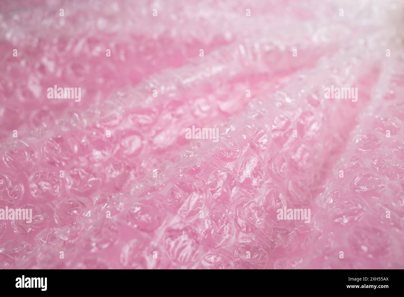 Plastic bubble wrap foil creases and waves on pink background, abstract ...