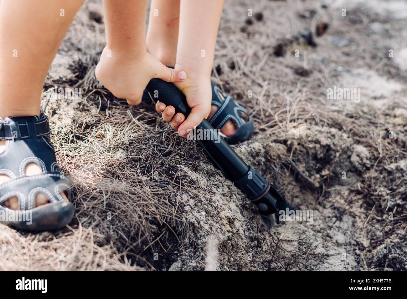 Cute boy digging soil in forest near sea beach. Family natural ...