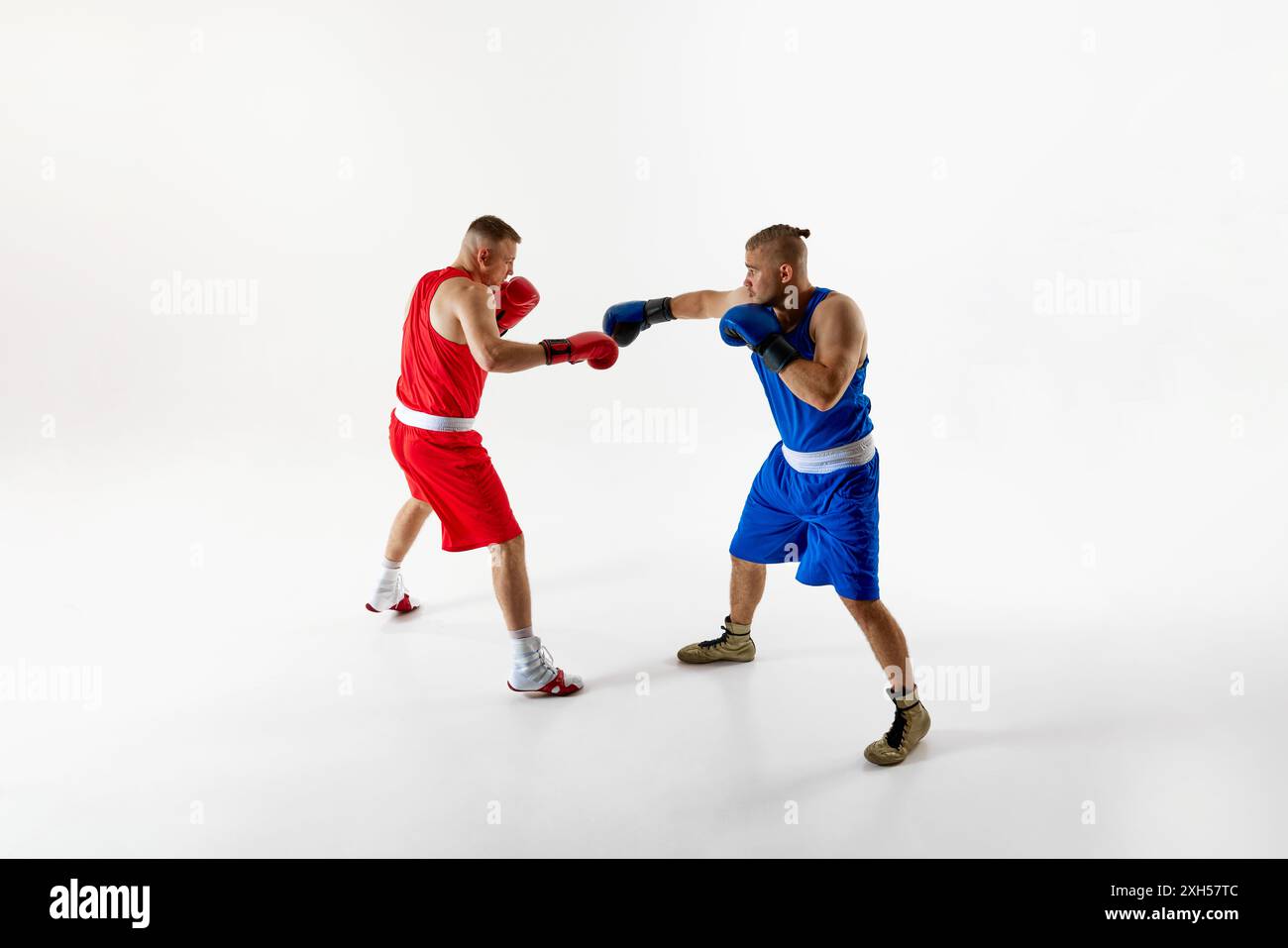 Two determined boxers in blue and red attire in action refining their ...