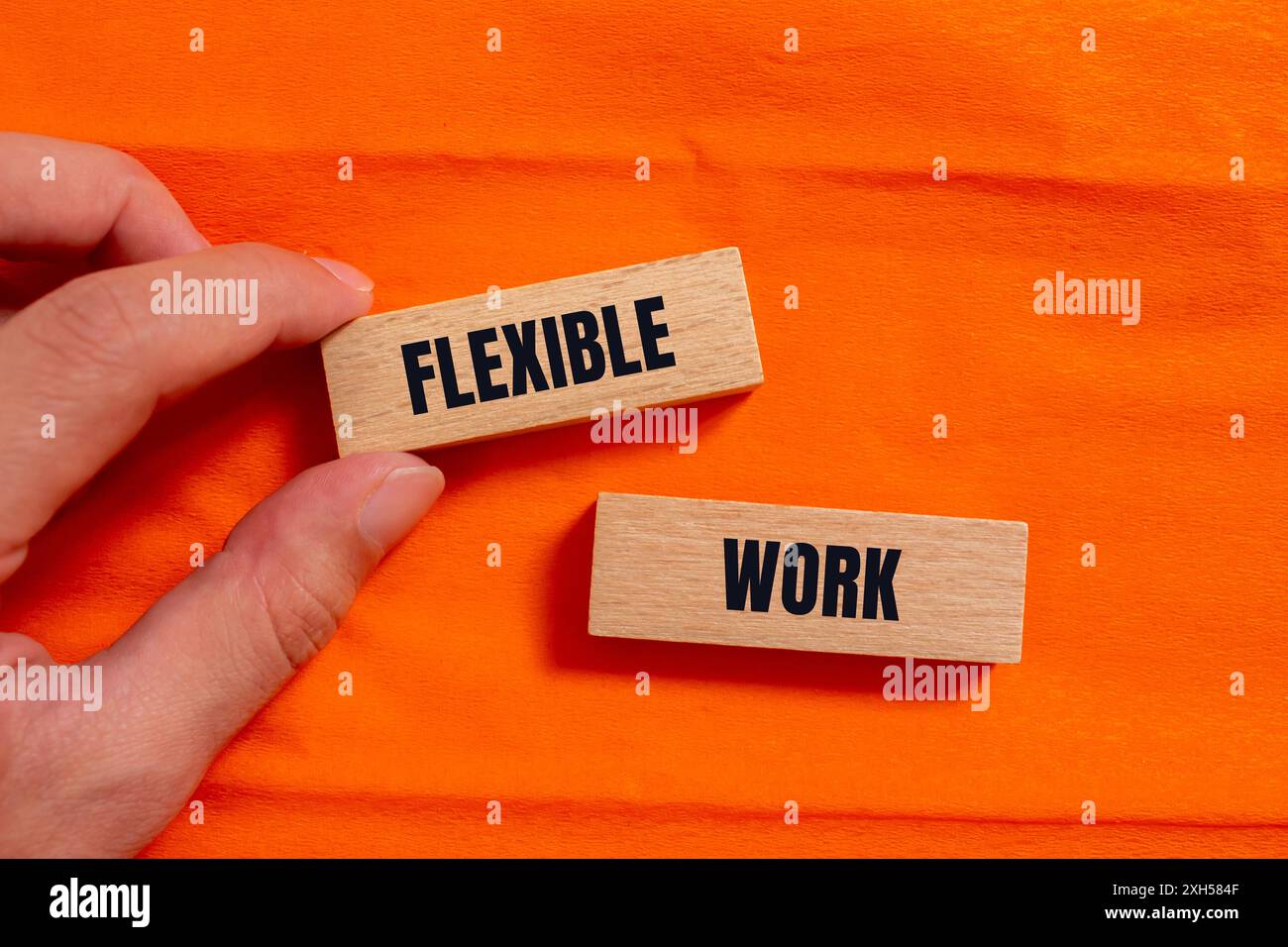 Flexible work message written on wooden blocks with orange background ...