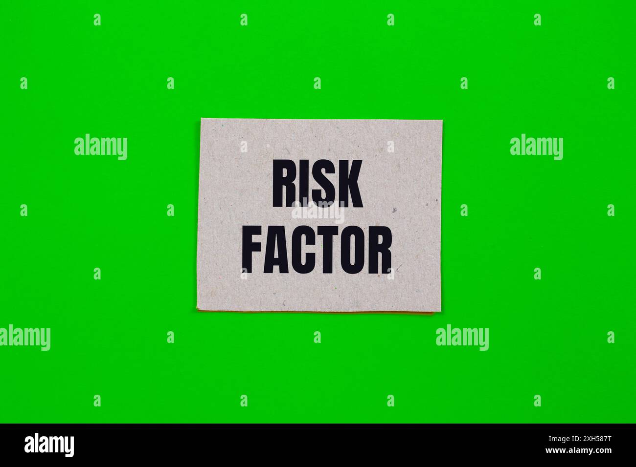 Risk factor message written on paper piece with green background ...