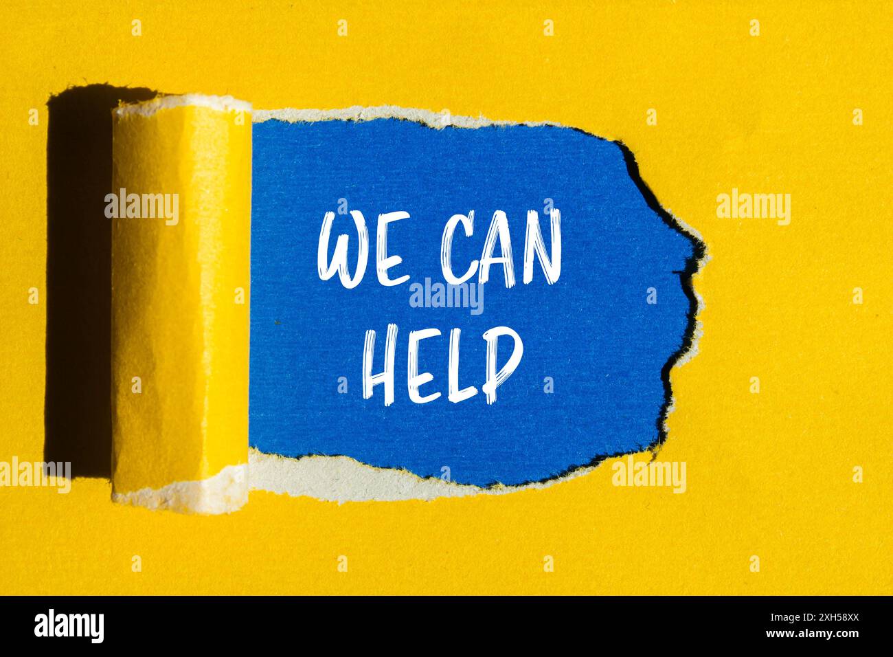 We can help message written on ripped yellow paper with blue background ...