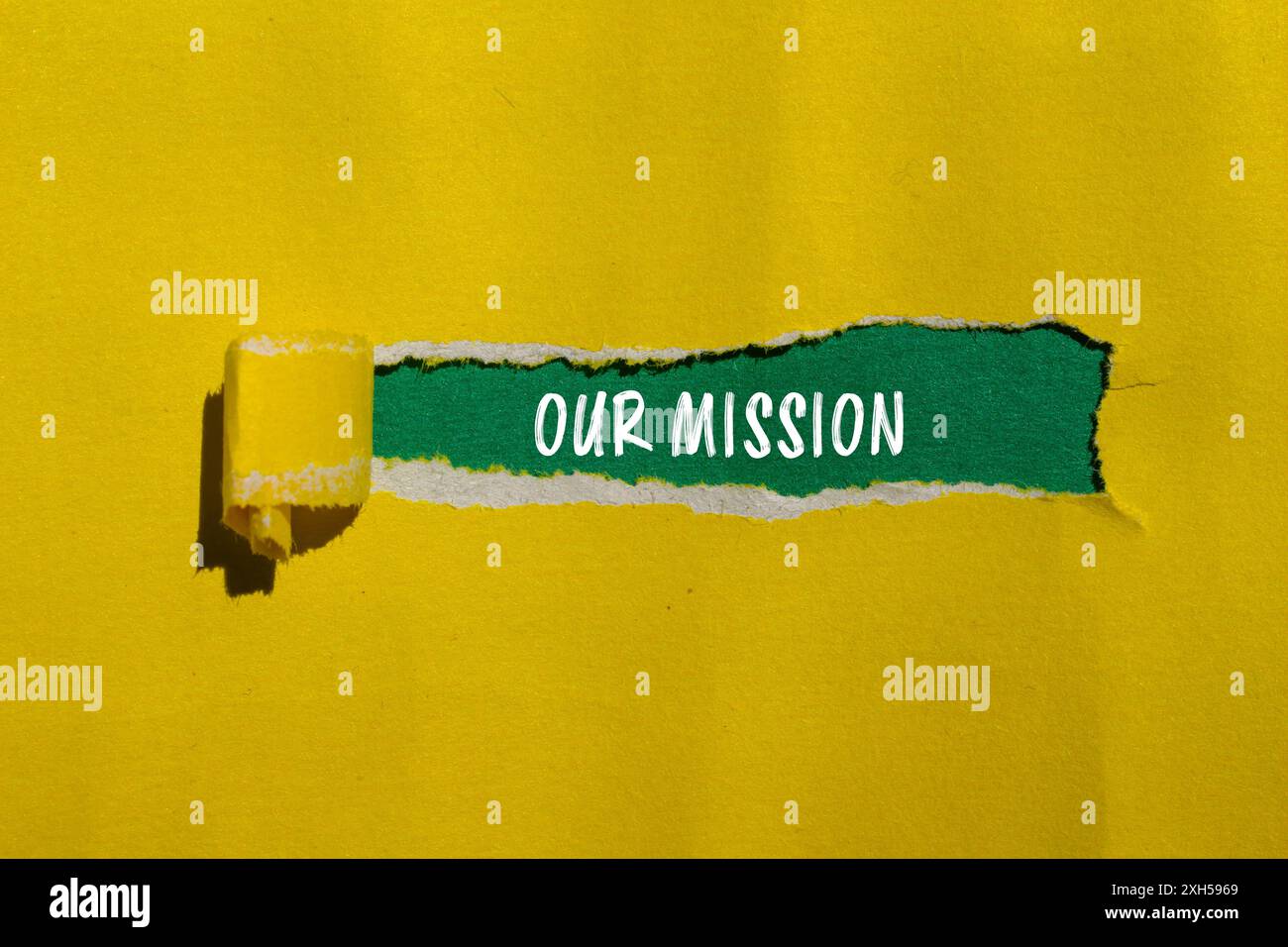 Our mission message written on ripped yellow paper with green ...